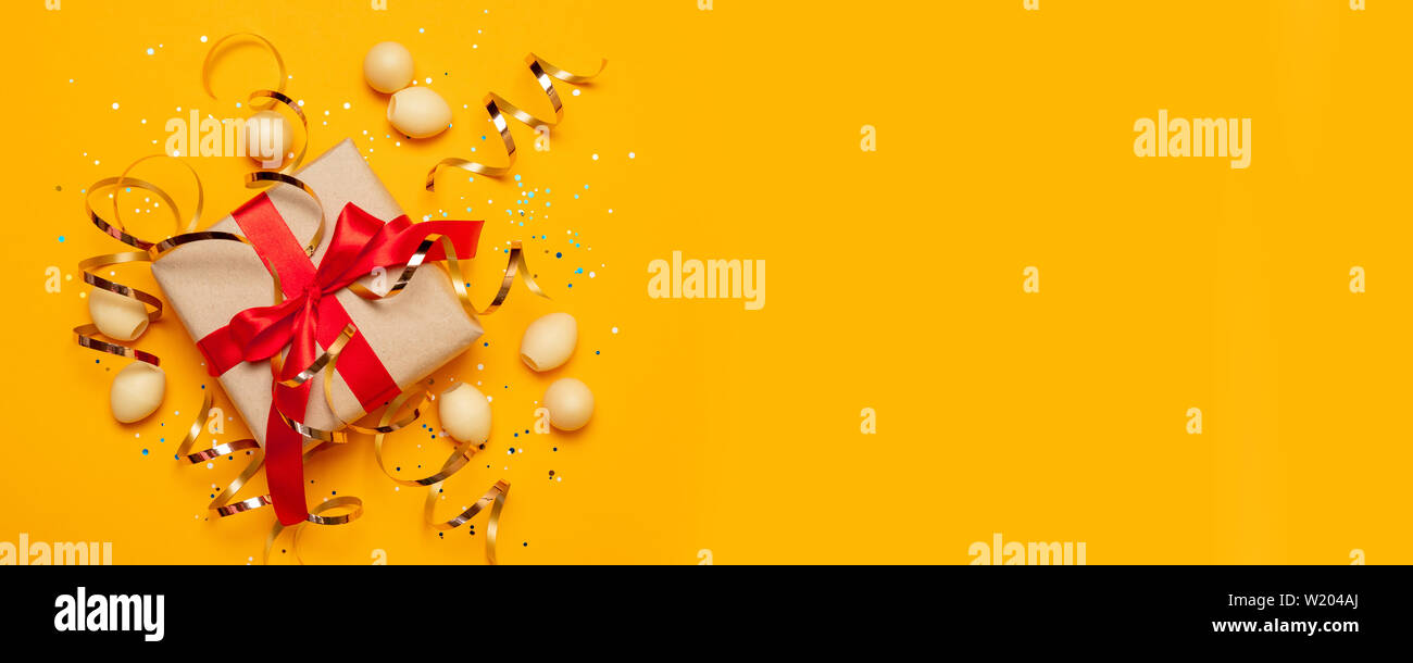 Holiday composition of surprise box with red bow ribbon, candy eggs ...
