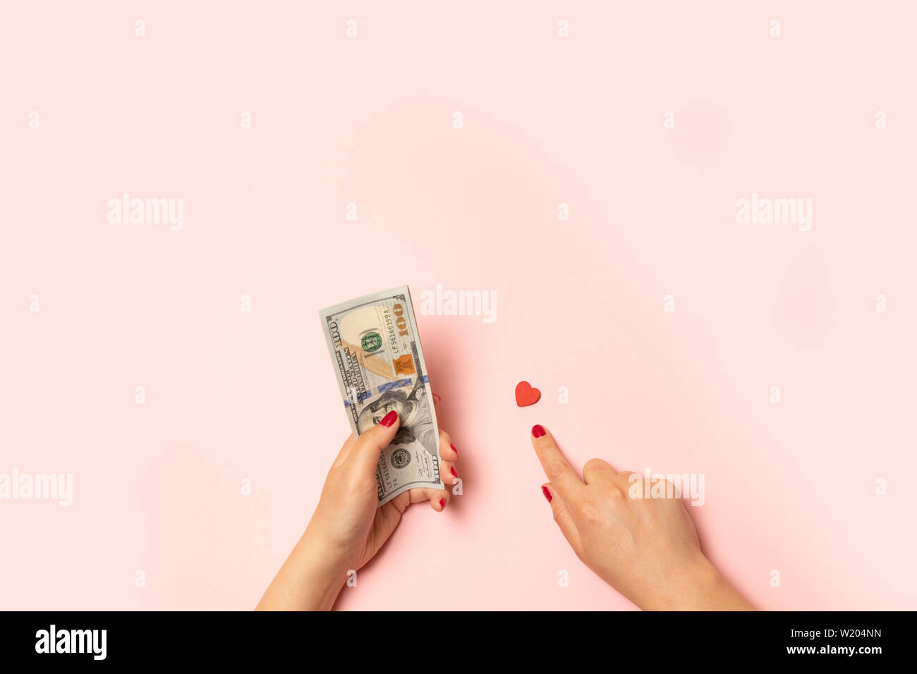 Selling love symbol. The human hand holds money in one hand and a red ...