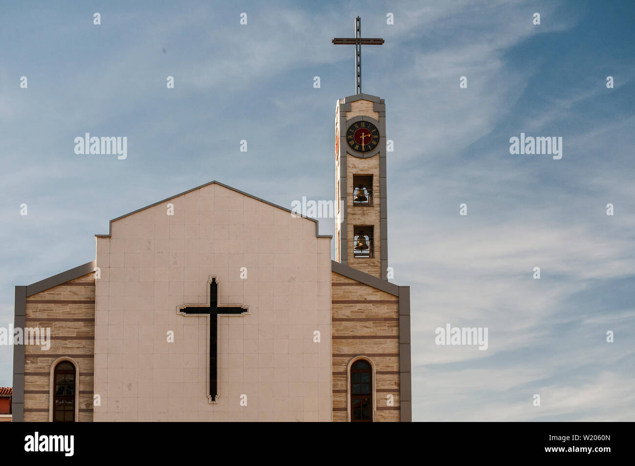 Contemporary catholic church building with bell tower and clock tower ...