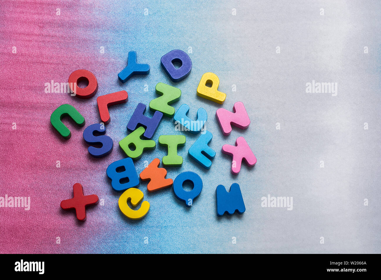 Colorful wooden letters scattered on a white background Stock Photo - Alamy