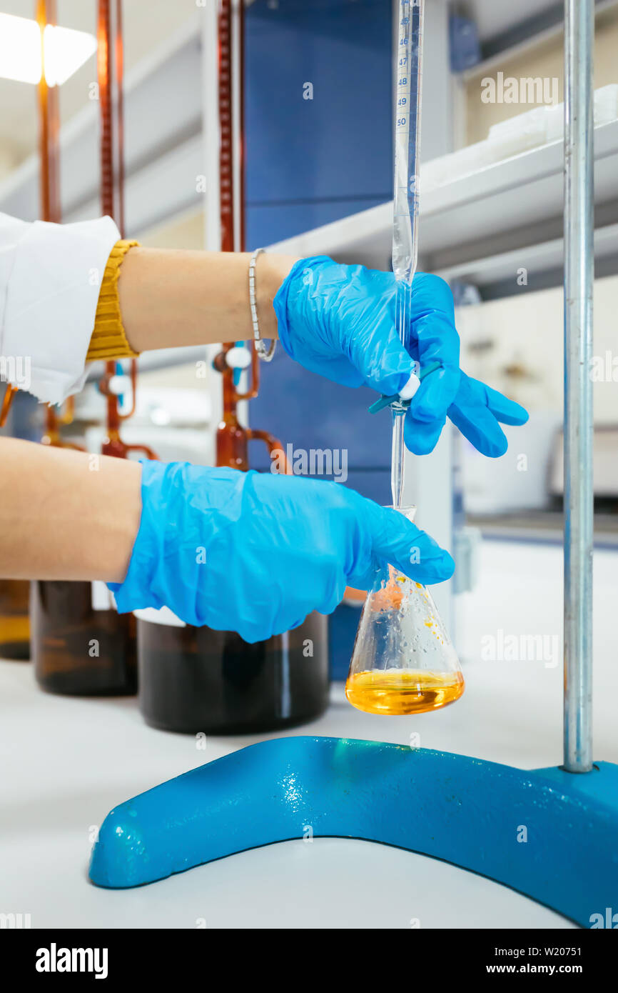Woman or female hands in protective gloves hold test tube in hands ...