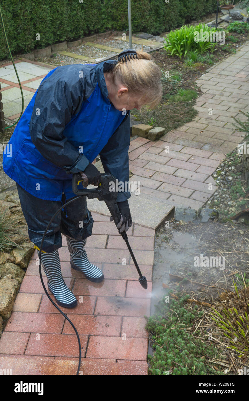Woman cleans stone slabs with a pressure washer Stock Photo - Alamy