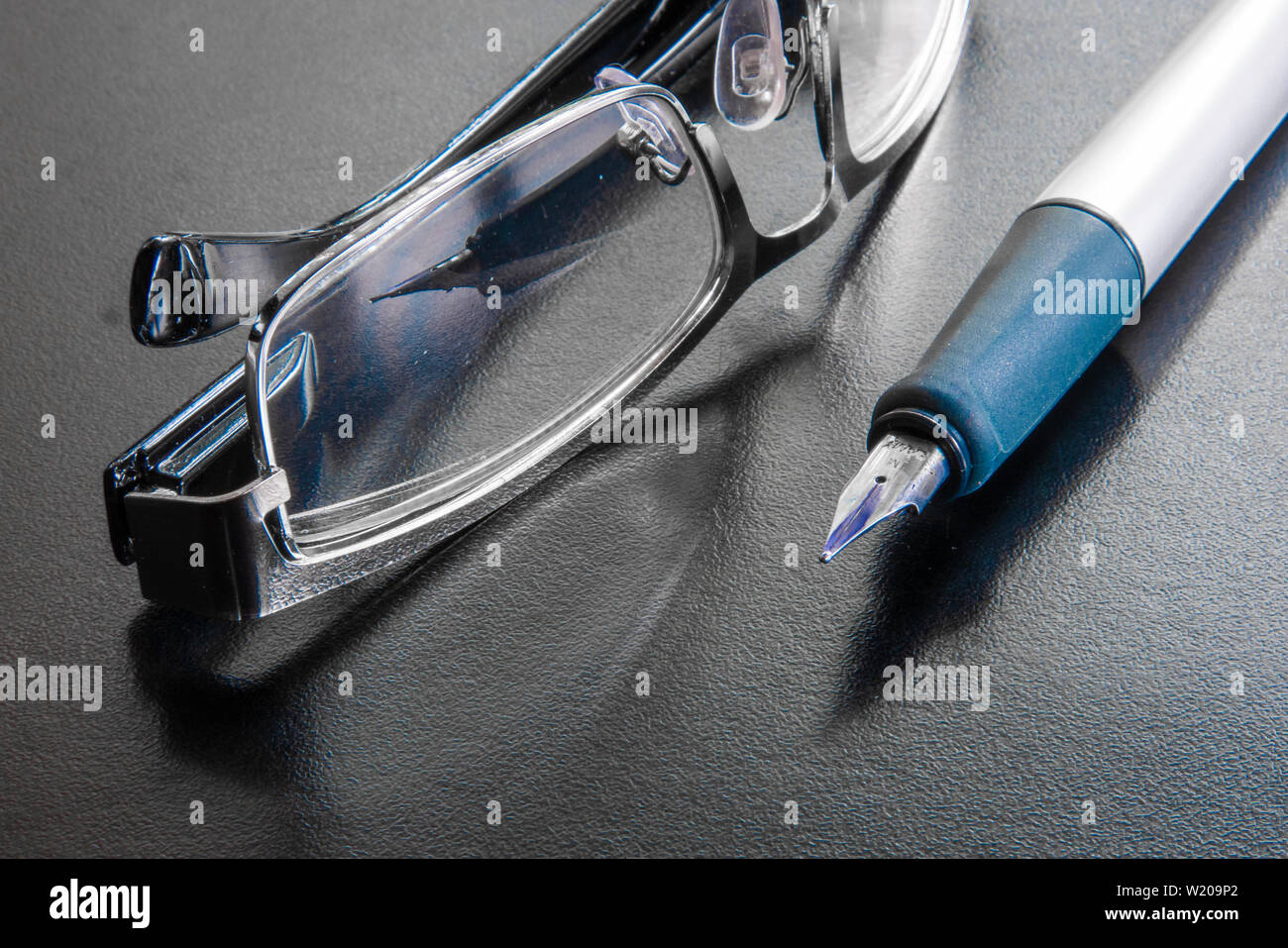 Fountain pen next to a pair of reading glasses. Illustration to ...