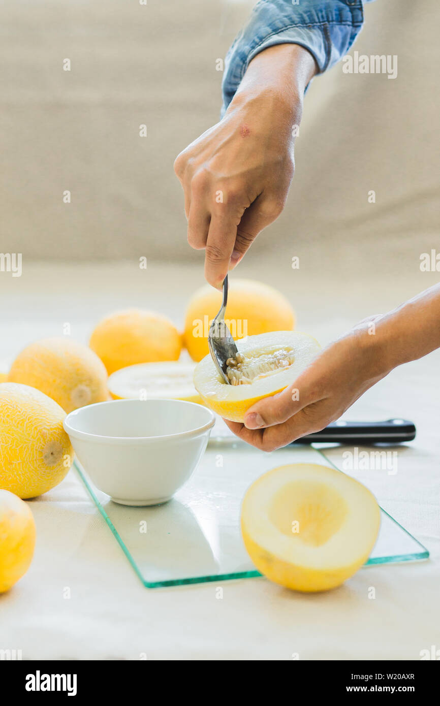 ripe melon berries on a bright kitchen table, in the hands of half a ...
