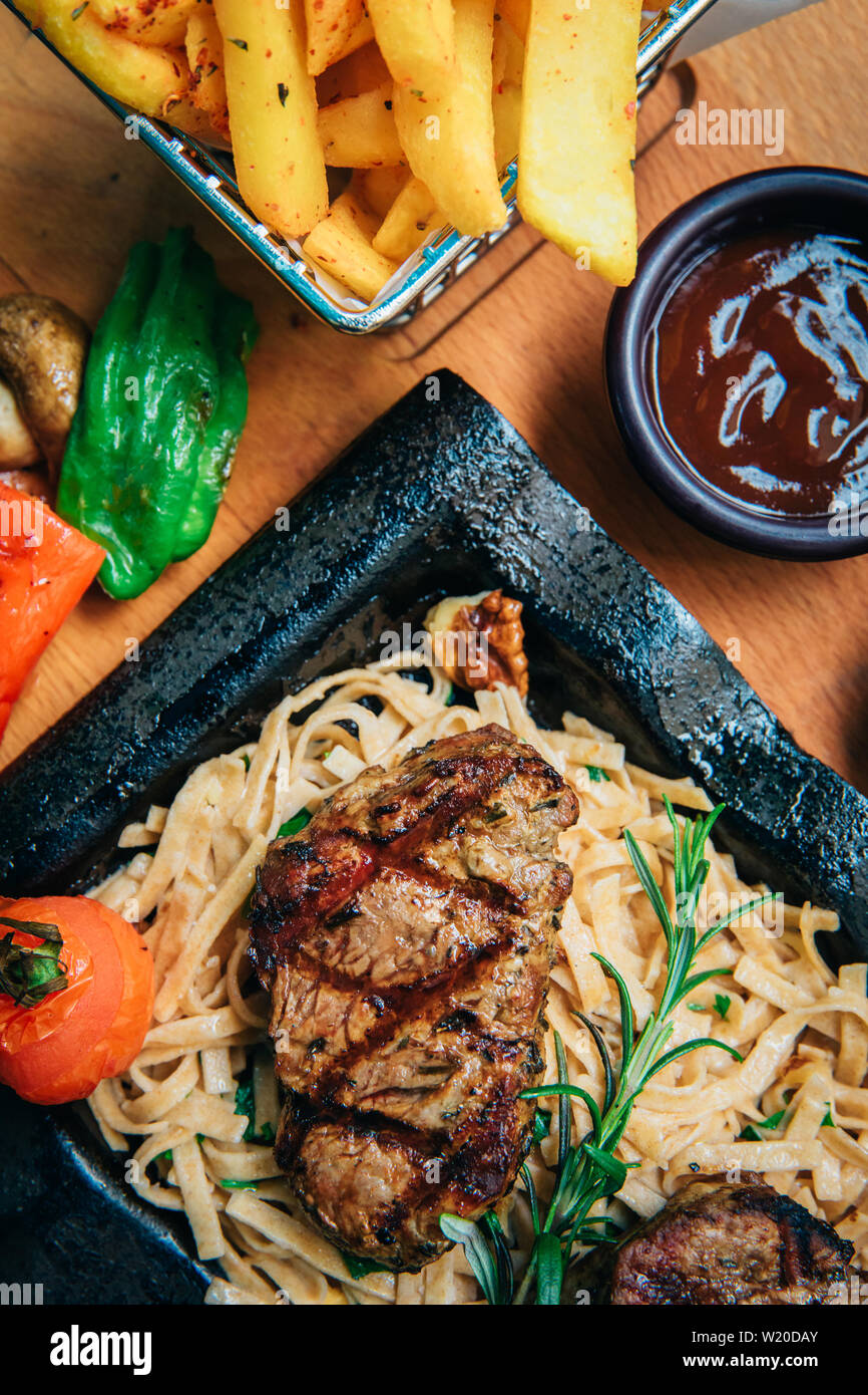 Grilled or roasted beef steak meat and pasta food meal with french ...