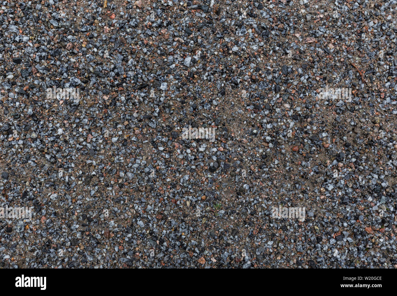 Close-up of wet sandy ground with gravel, viewed from above. High ...