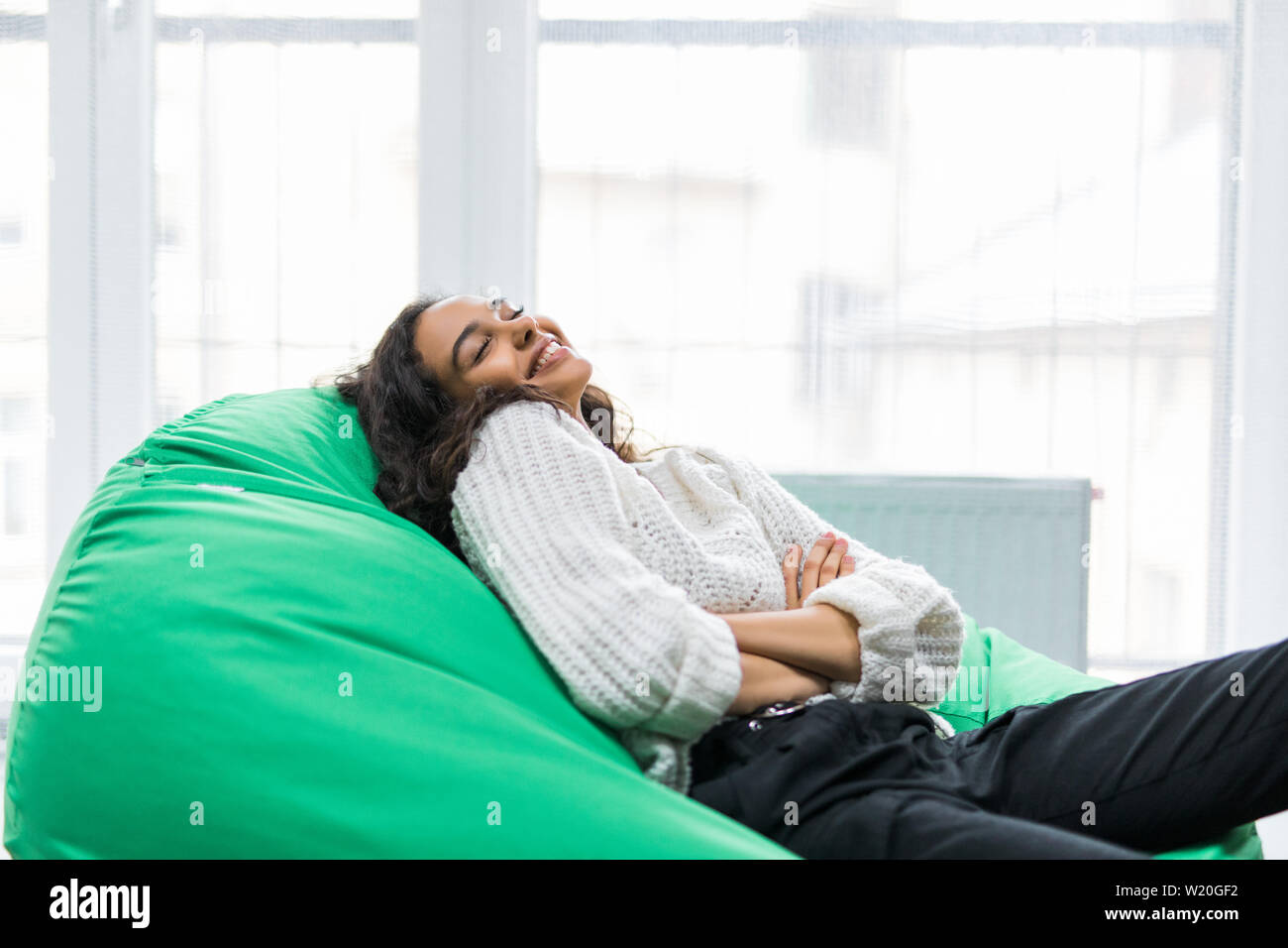 Young woman, lying on the poof at home Stock Photo - Alamy