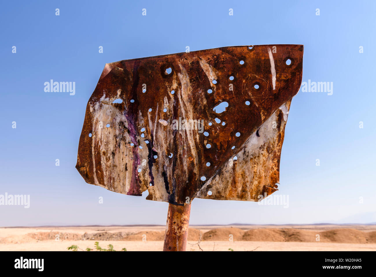 Old metal sign covered in rust and filled with holes after being shot ...