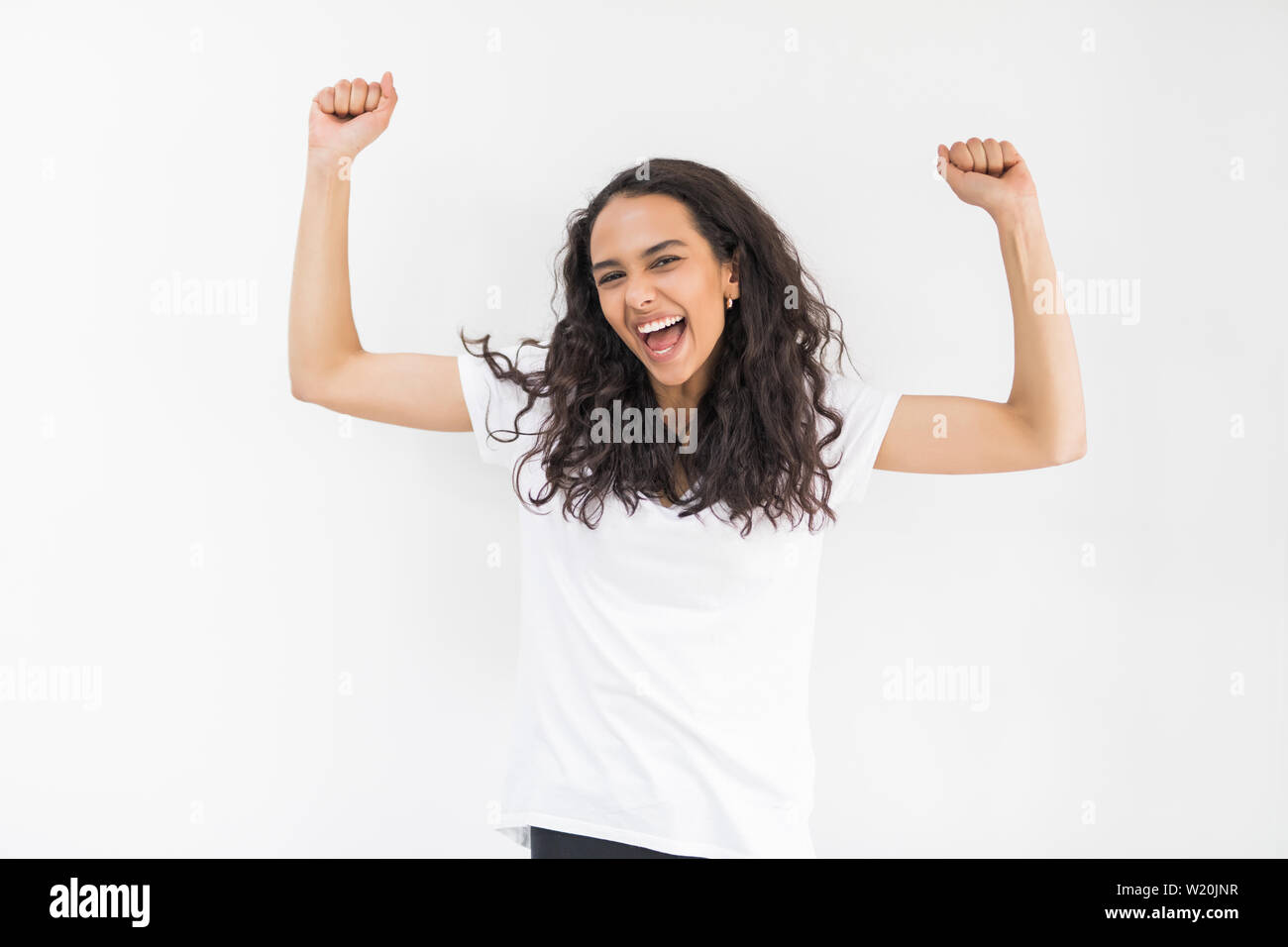 Young woman with win gesture and raised hands isolated on white ...