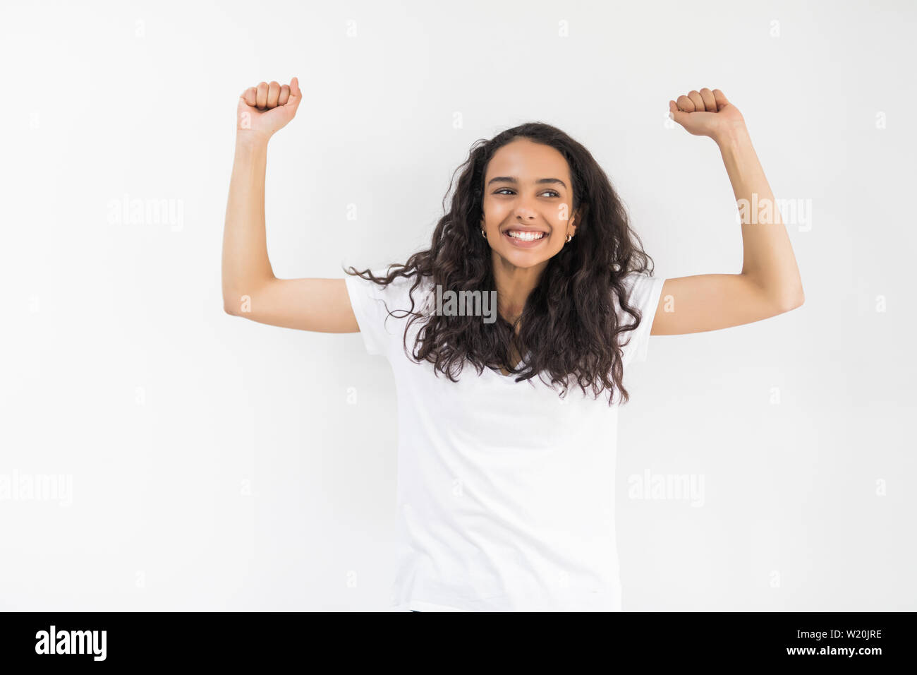 Young woman with win gesture and raised hands isolated on white ...
