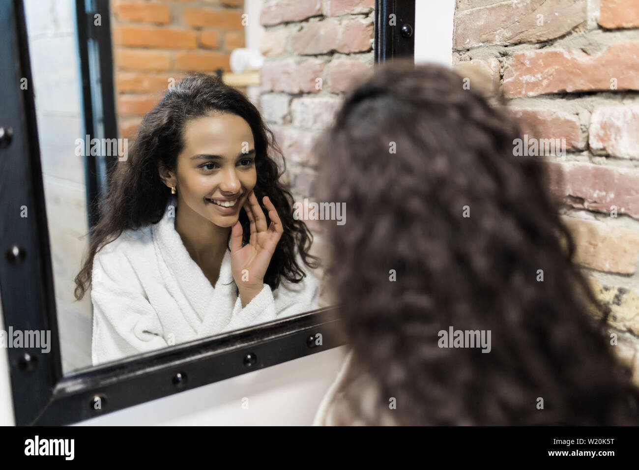 Woman looking on reflection in the mirror after shower Stock Photo - Alamy