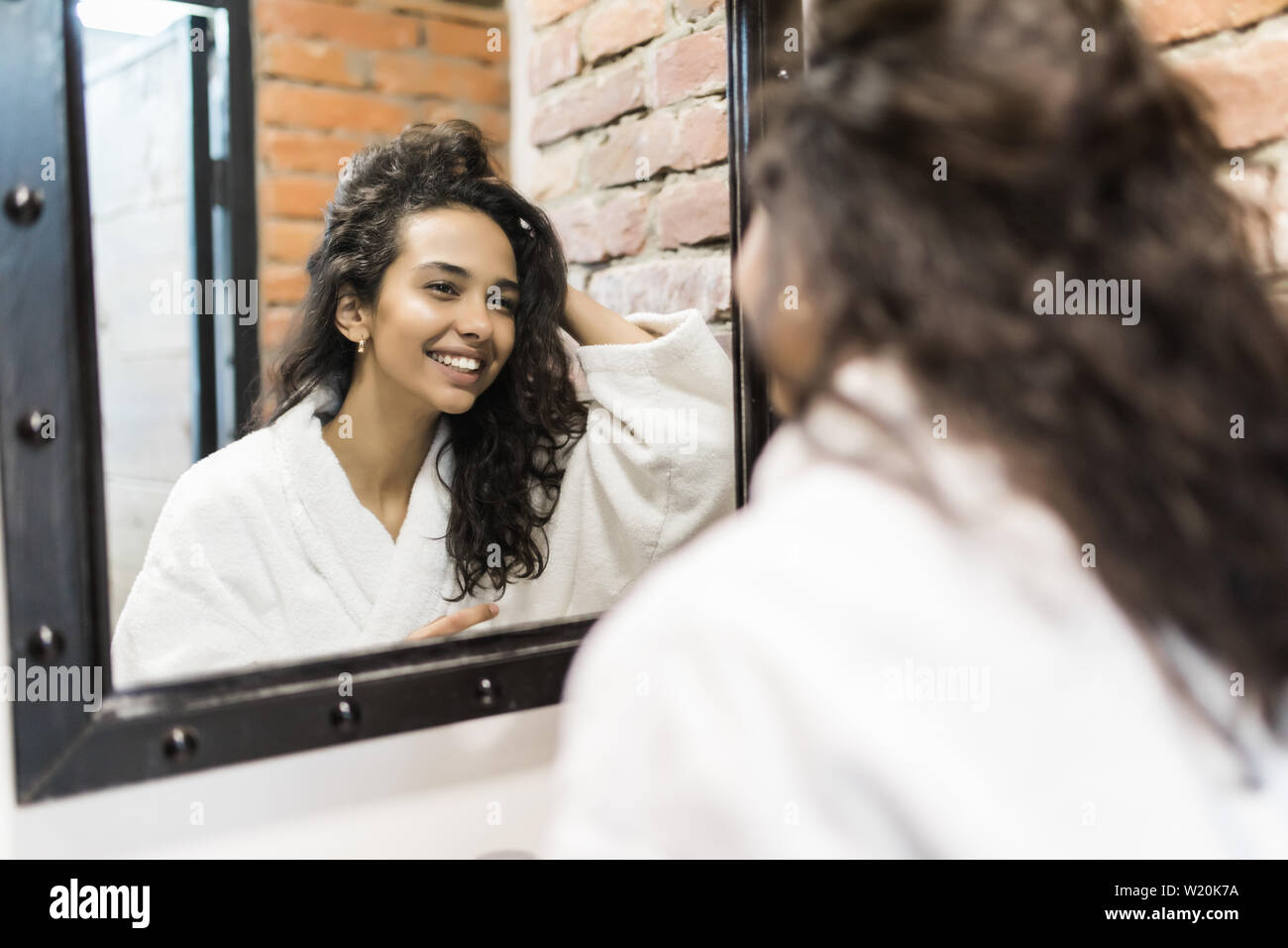 Woman looking on reflection in the mirror after shower Stock Photo - Alamy
