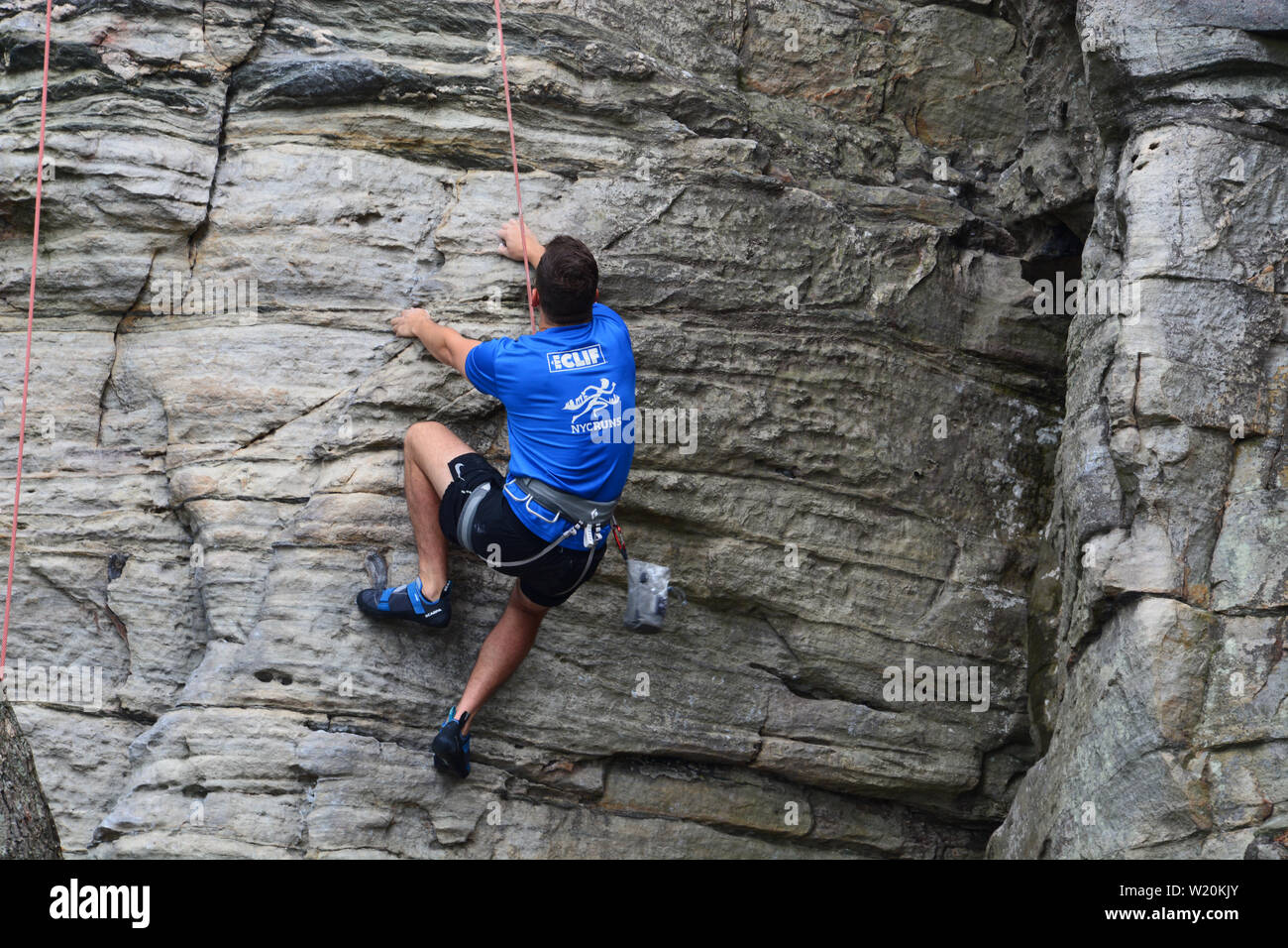 A young male climber works his way up a cliff face on the Ledge Spring ...