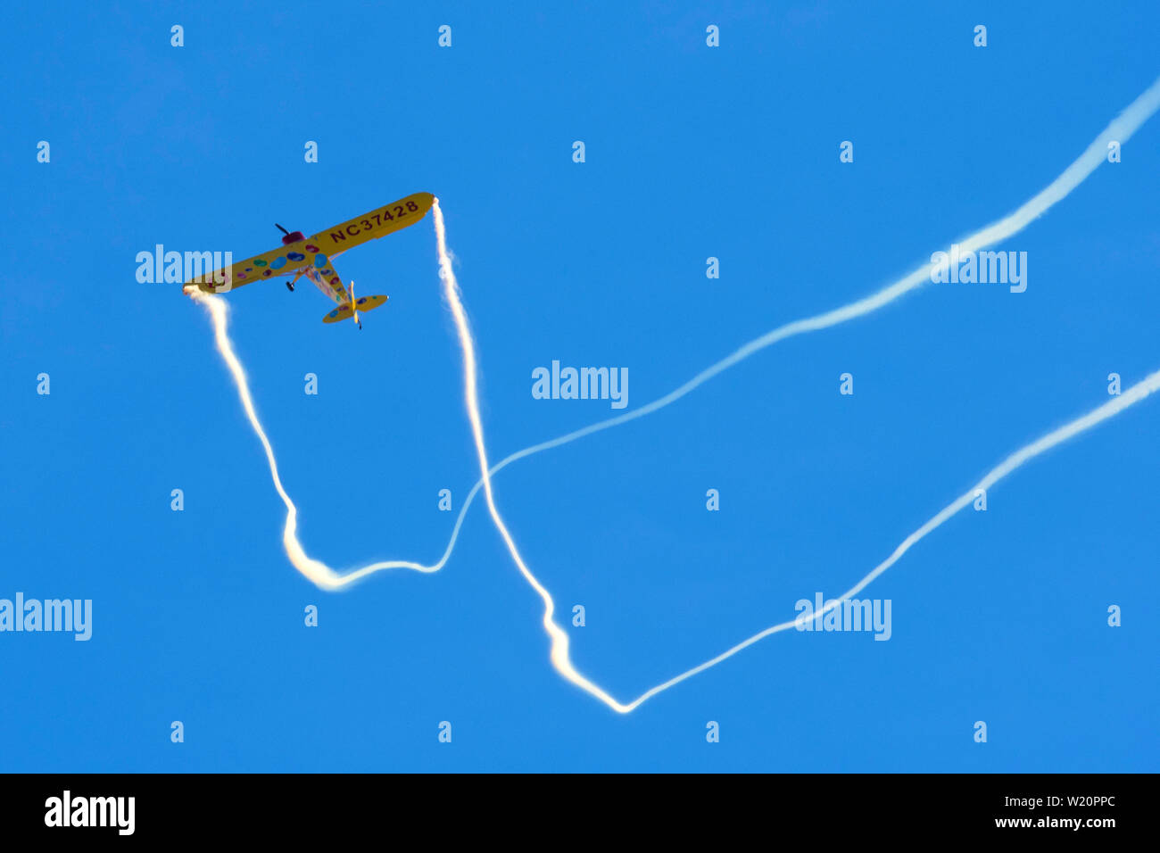 a yellow plane flying Stock Photo - Alamy