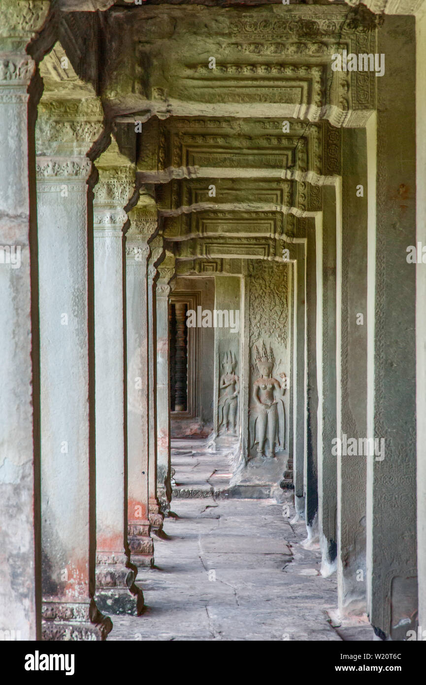 A hallway with ornately carved pillars and apsaras inside Angkor Wat ...