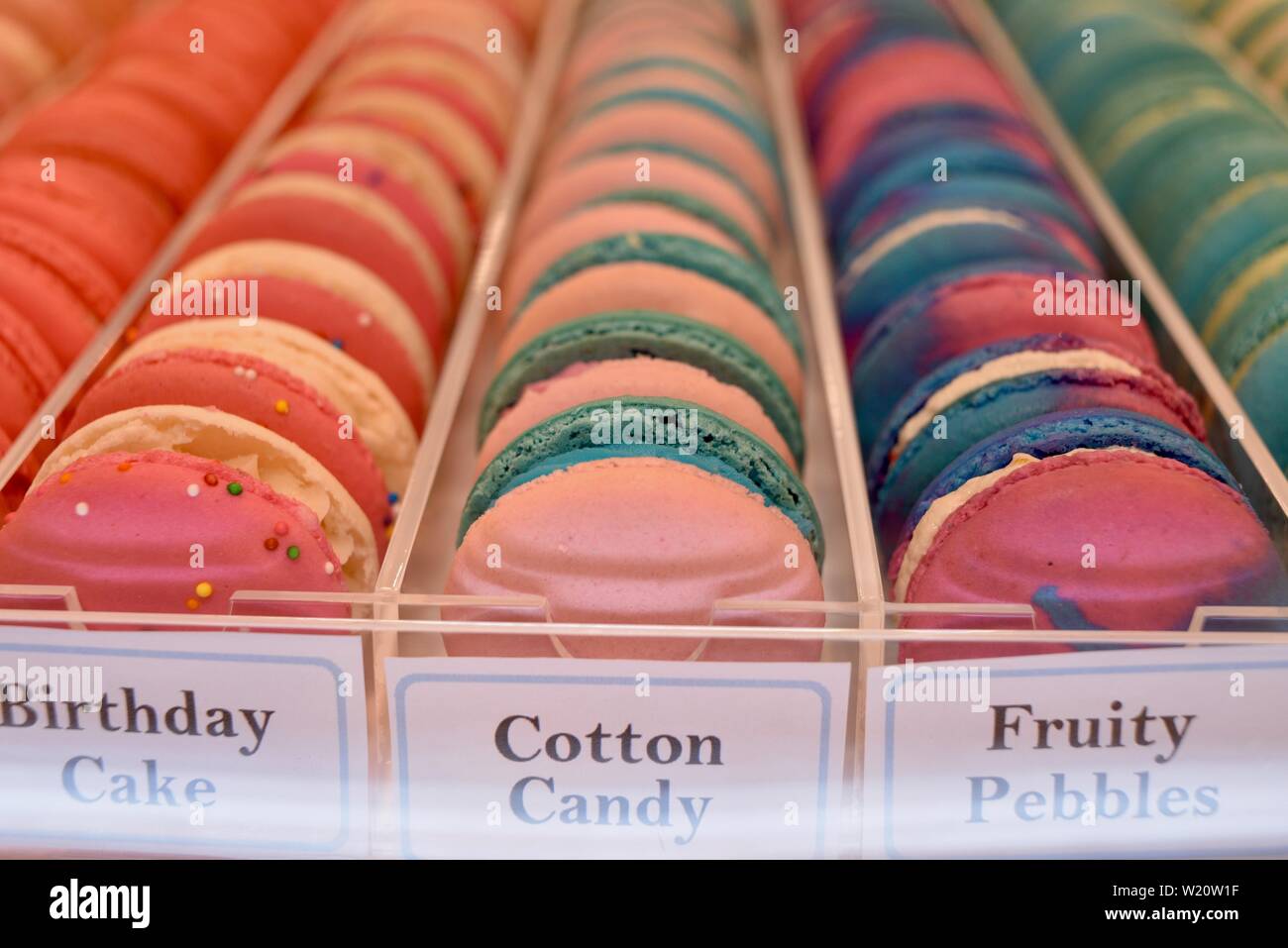 Rows of brightly colored French macarons from Le Petit Sucre on display ...