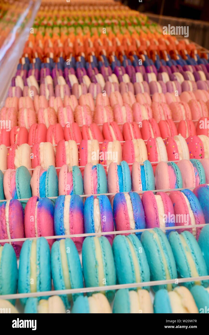 Rows of brightly colored French macarons from Le Petit Sucre on display ...