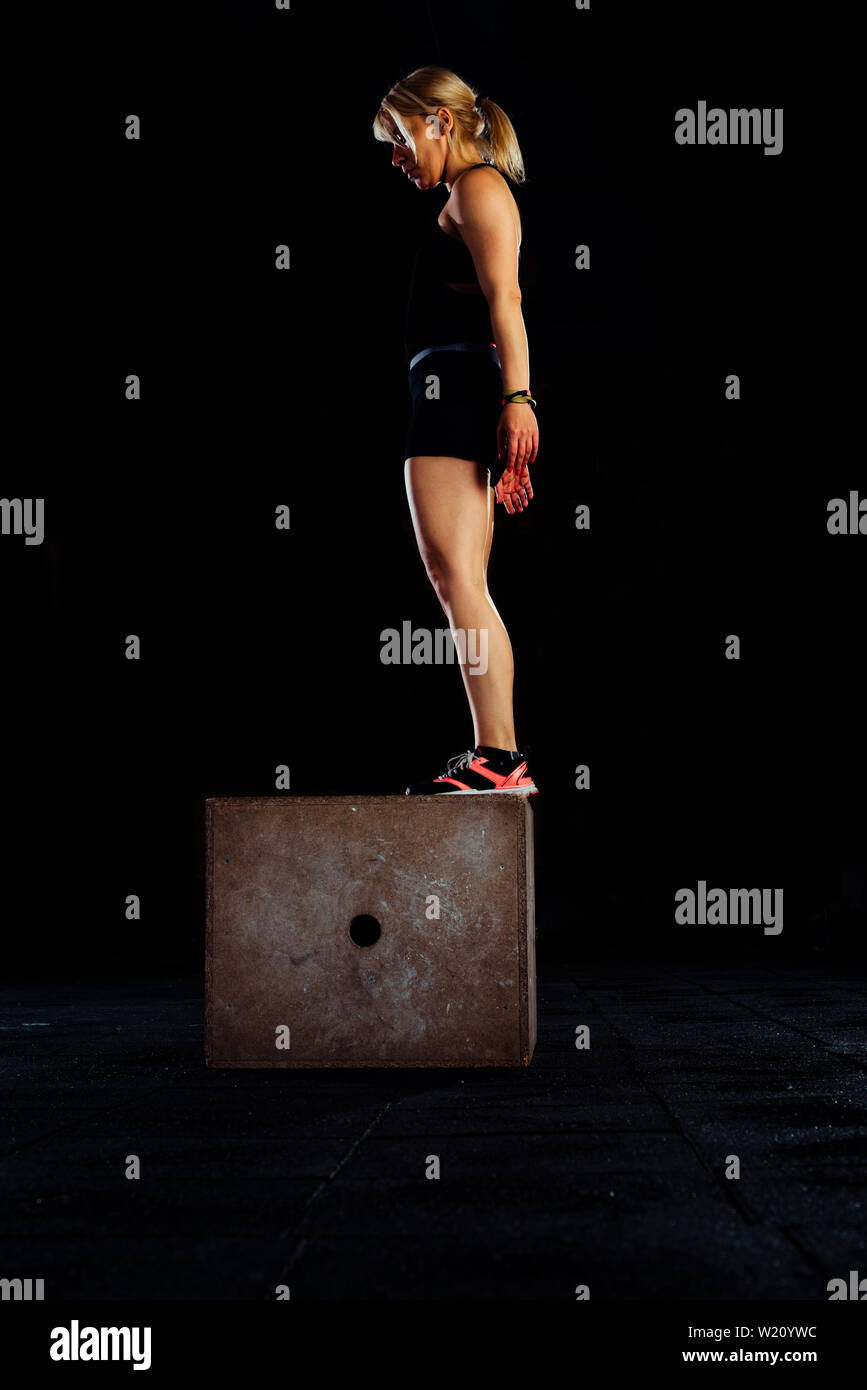 Female athlete is performing box jumps at gym Stock Photo - Alamy