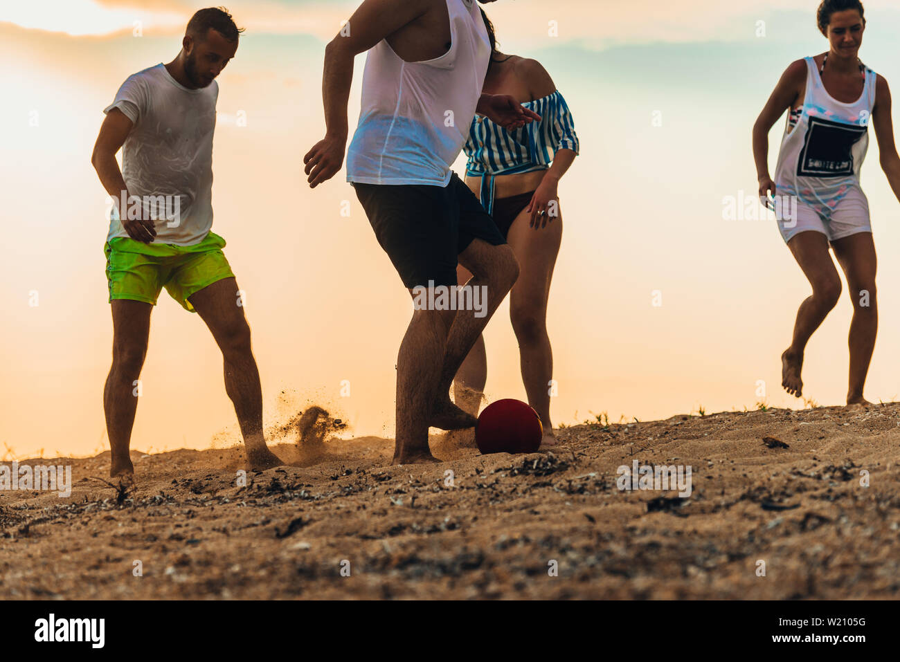 Group of young people playing soccer and competing together on a sandy ...