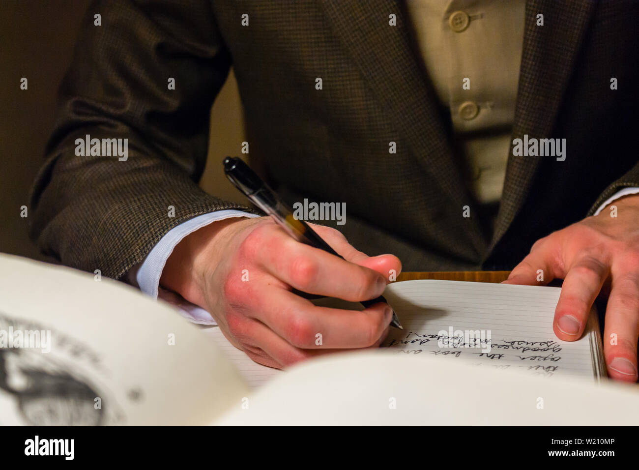 Man writing a letter while reading books Stock Photo - Alamy