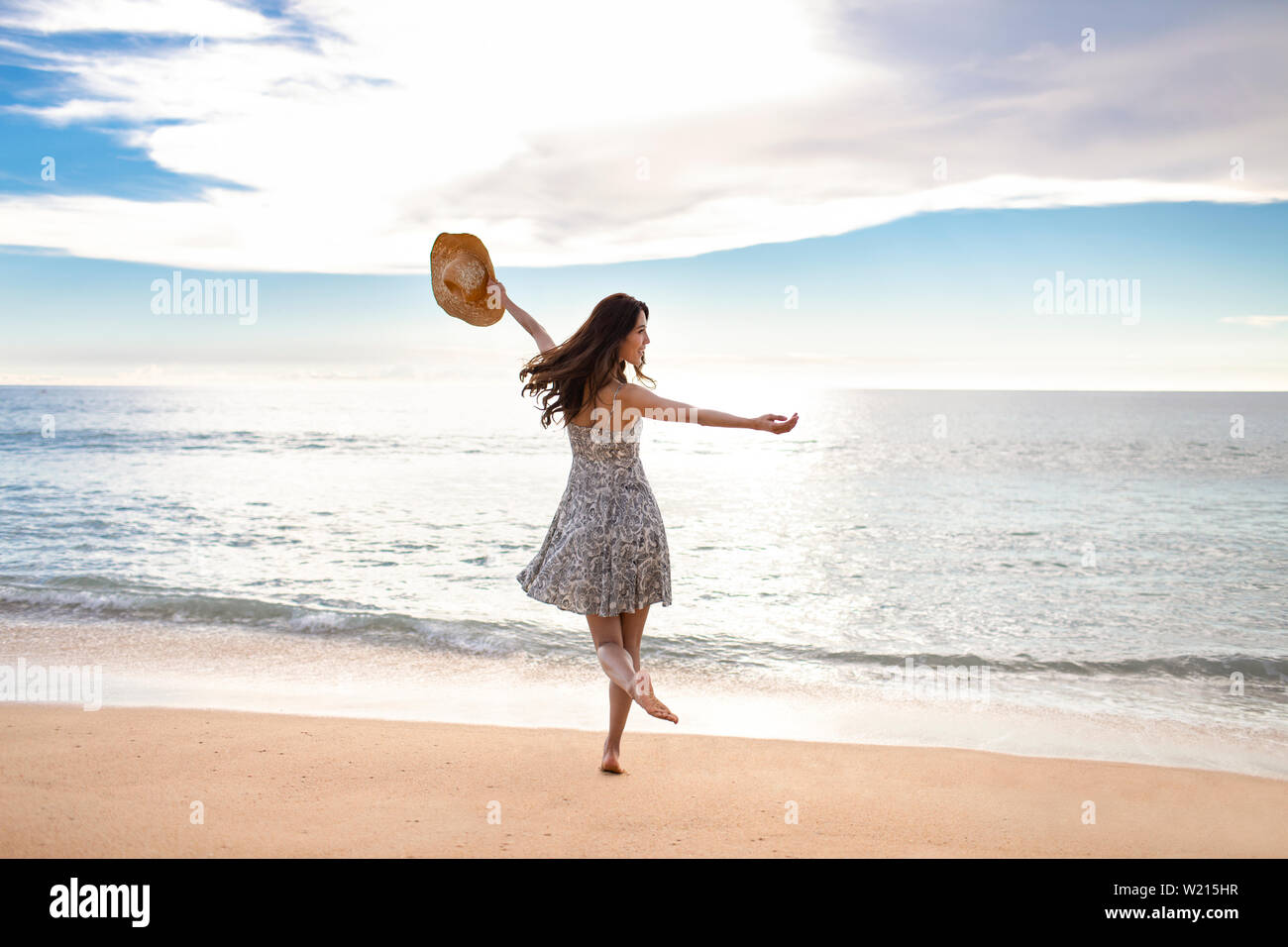 Happy young woman dancing on beach Stock Photo - Alamy
