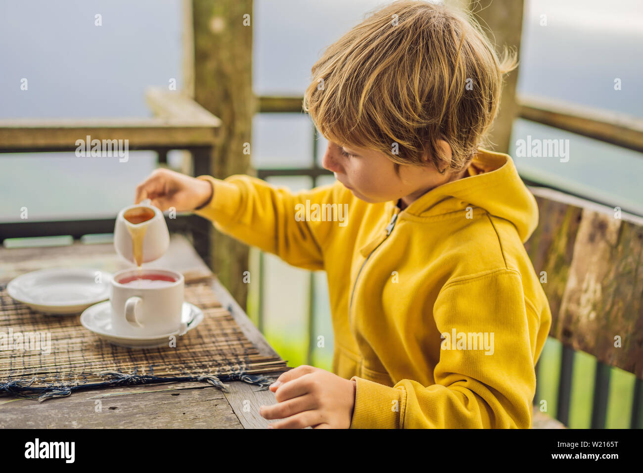 Boy drinking tea in a cafe in the mountains Stock Photo - Alamy