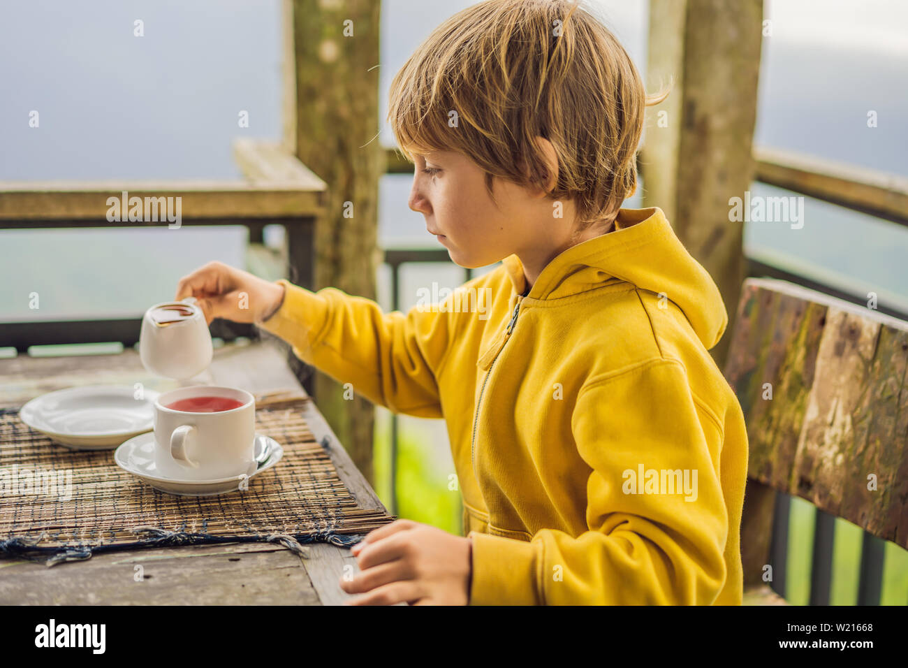 Boy drinking tea in a cafe in the mountains Stock Photo - Alamy