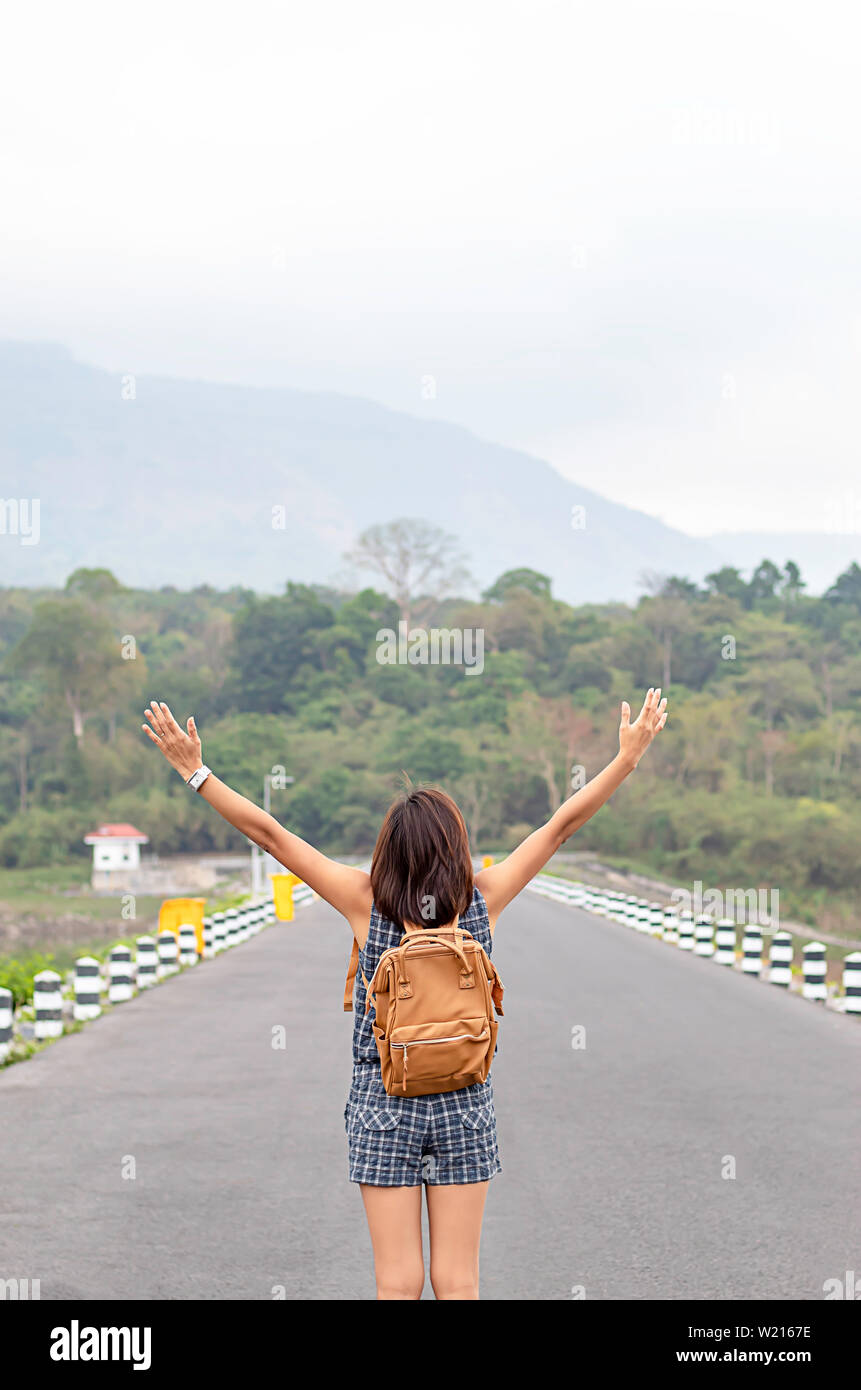 Women raise their arms and shoulder backpack Background mountains at ...