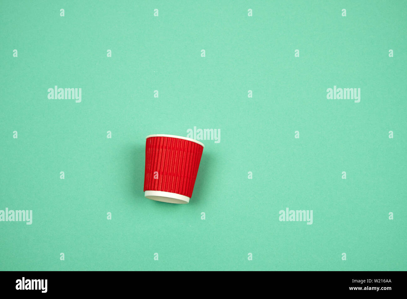 red paper cup with corrugated edges for hot drinks on a green ...