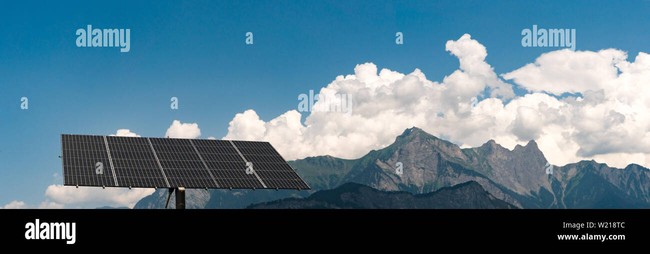 A large free-standing solar panel with panorama mountain landscape in ...