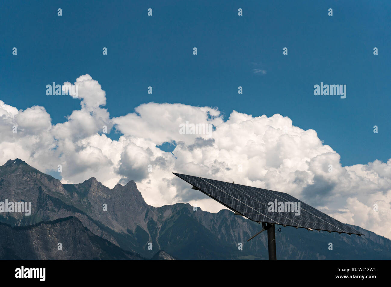 A large free-standing solar panel with mountain landscape in the Swiss ...