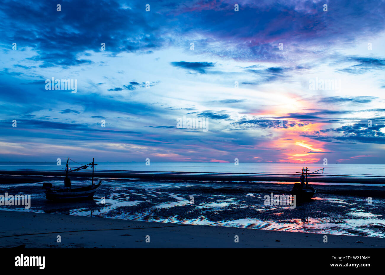 The morning sun light in the sea, and the boat on the beach Stock Photo ...