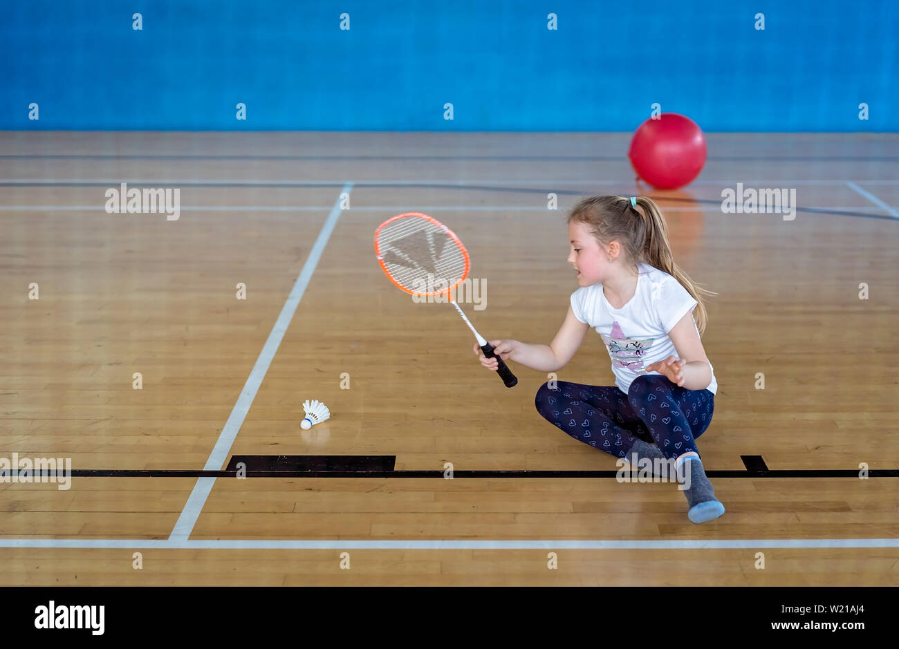 Cute little Caucasian girl playing badminton in an indoor sport and ...