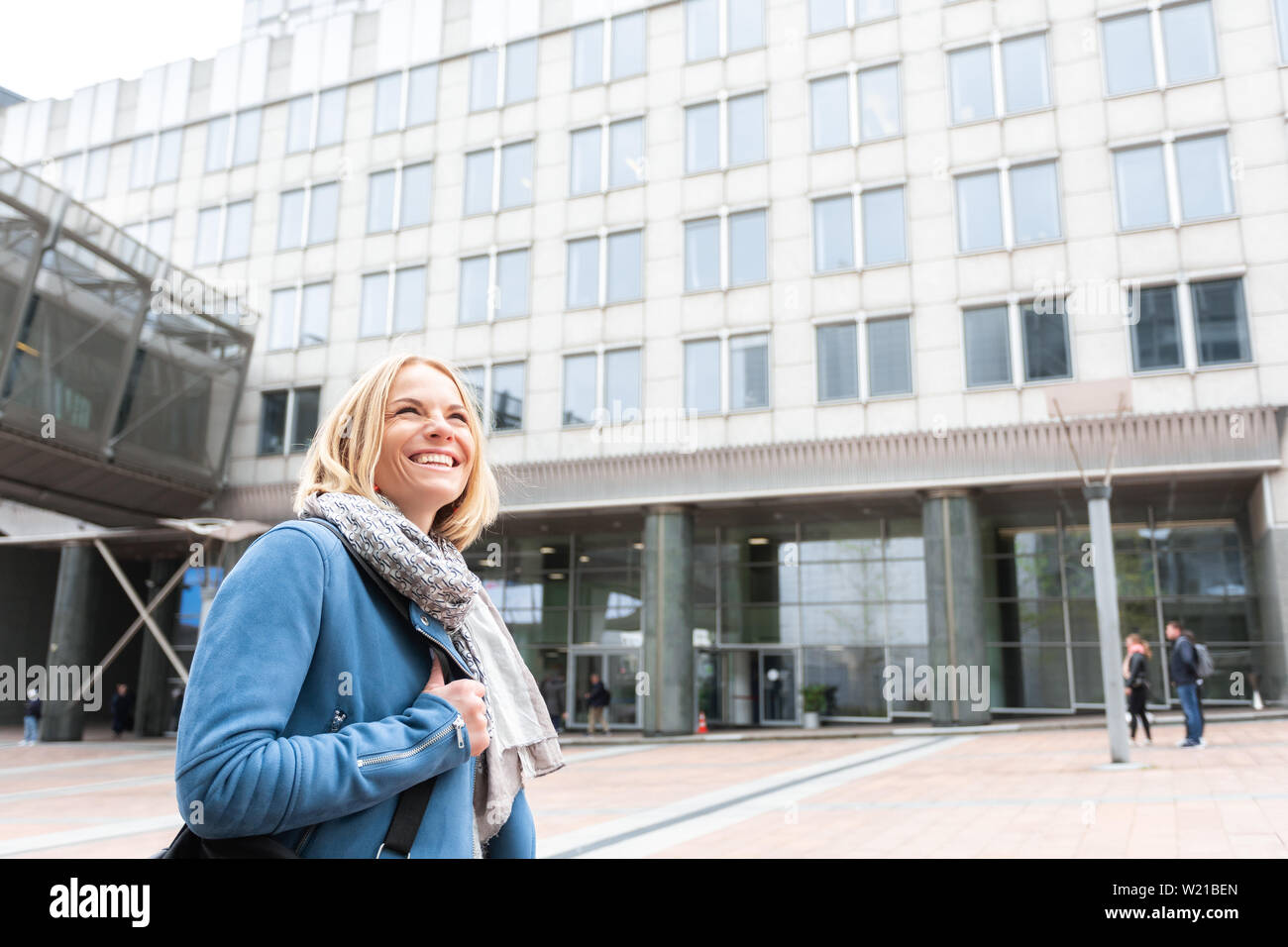 Business woman in casual clothes walking down the street in front of a ...