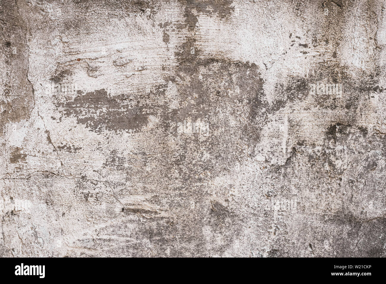Gray and brown shabby concrete wall with flaky plaster. Torn rough old ...