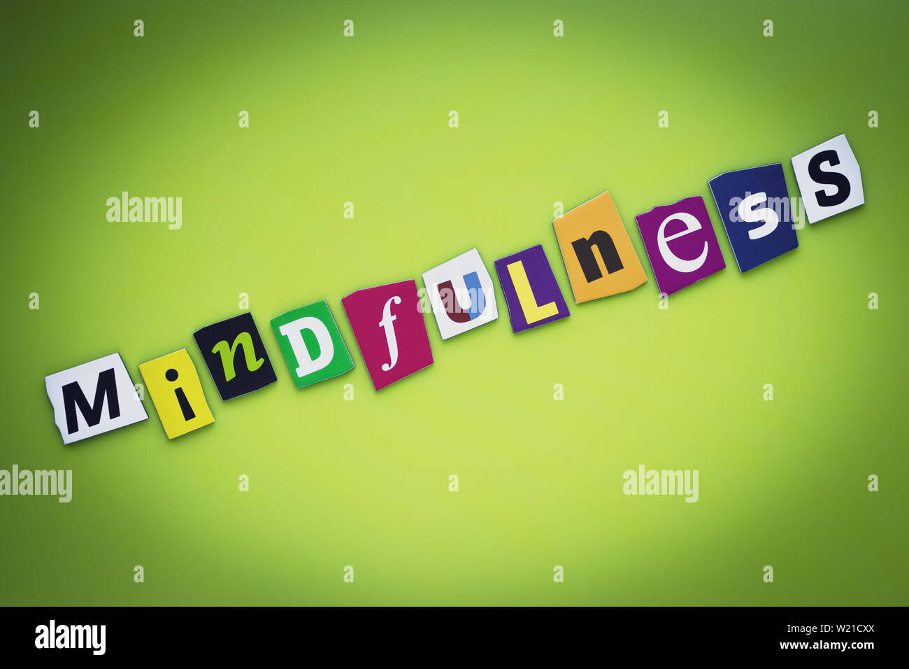 Word mindfulness from cut letters on green background. Psychologic ...