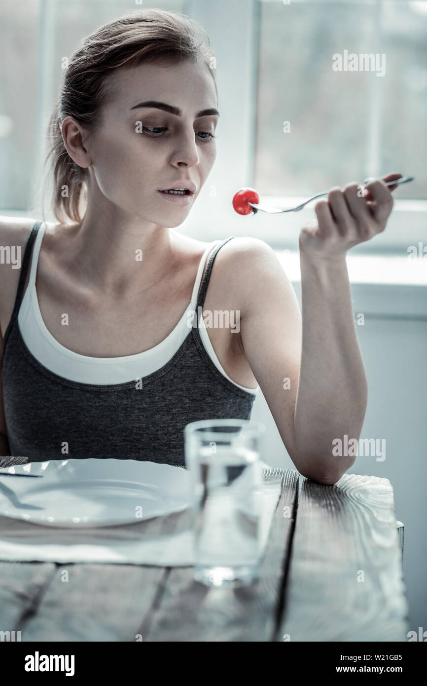 Personal diet. Concentrated young female having sickly look while being ...