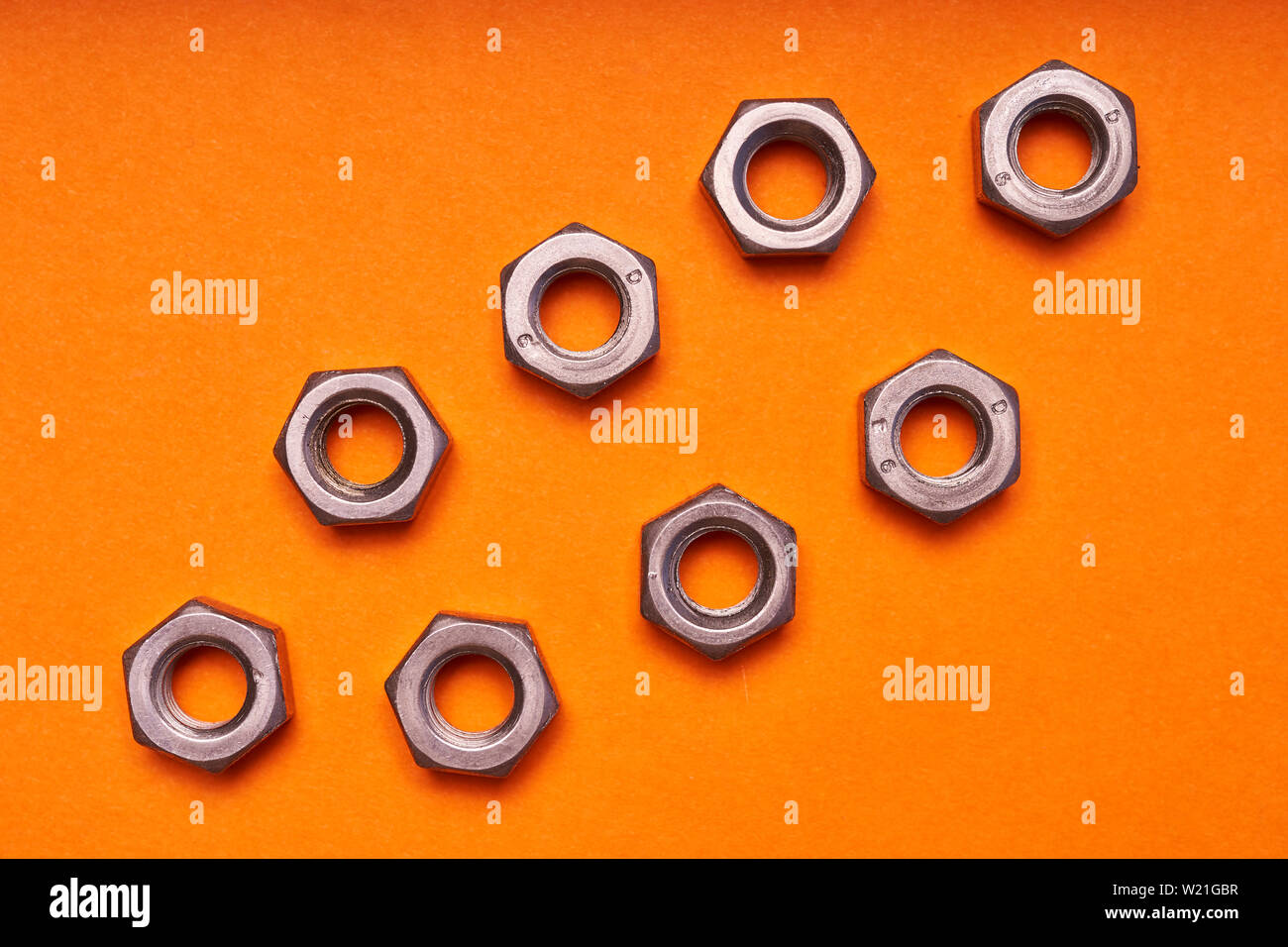 hex nuts on orange background. Bolted connection elements Stock Photo ...