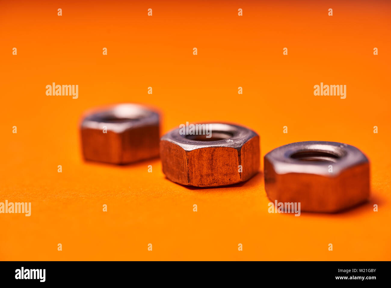 hex nuts on orange background. Bolted connection elements Stock Photo ...
