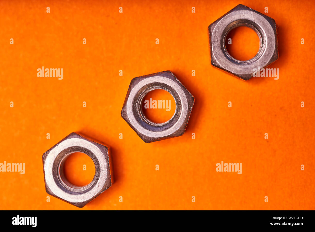 hex nuts on orange background. Bolted connection elements Stock Photo ...