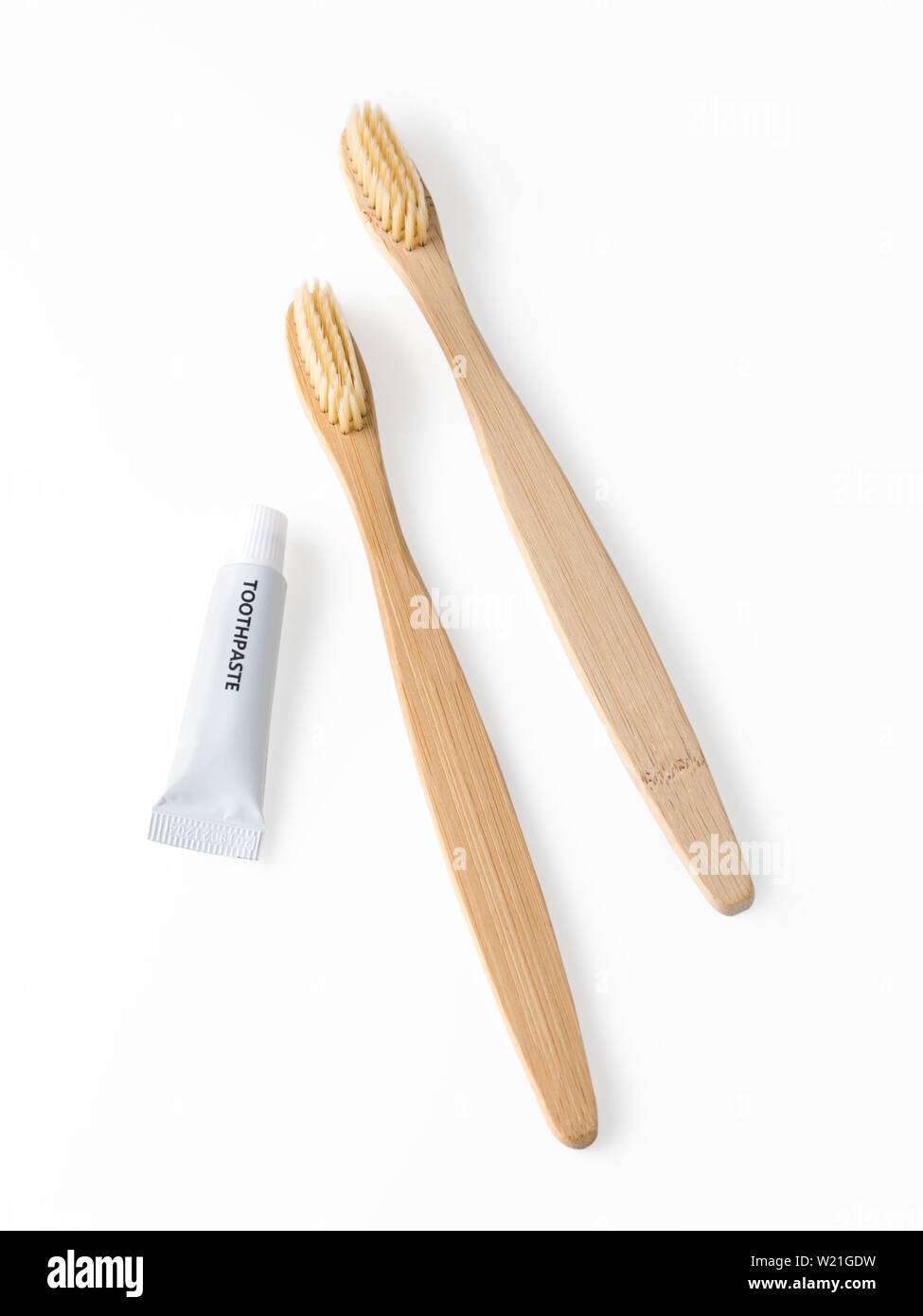 Bamboo toothbrush with travel sized toothpaste isolated on white ...