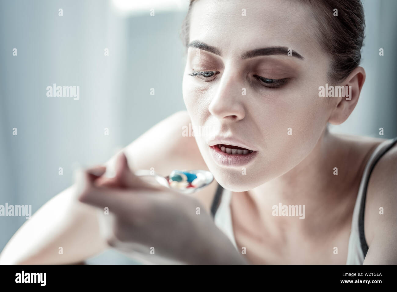 Health problems. Serious female person opening mouth while looking at ...