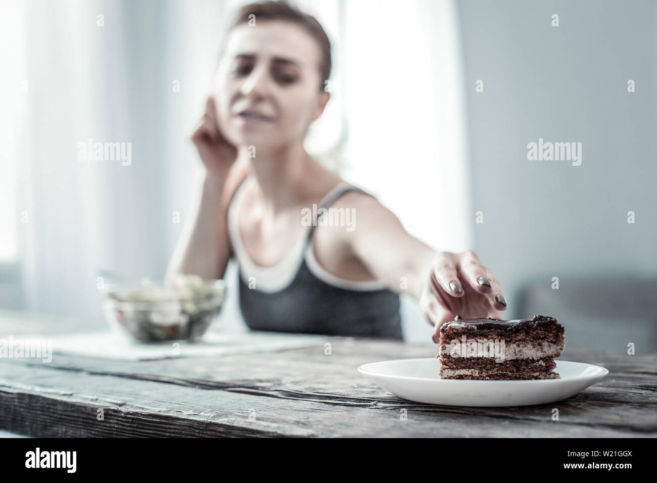 It is mine. Emotional girl stretching hand while going to touch cake ...