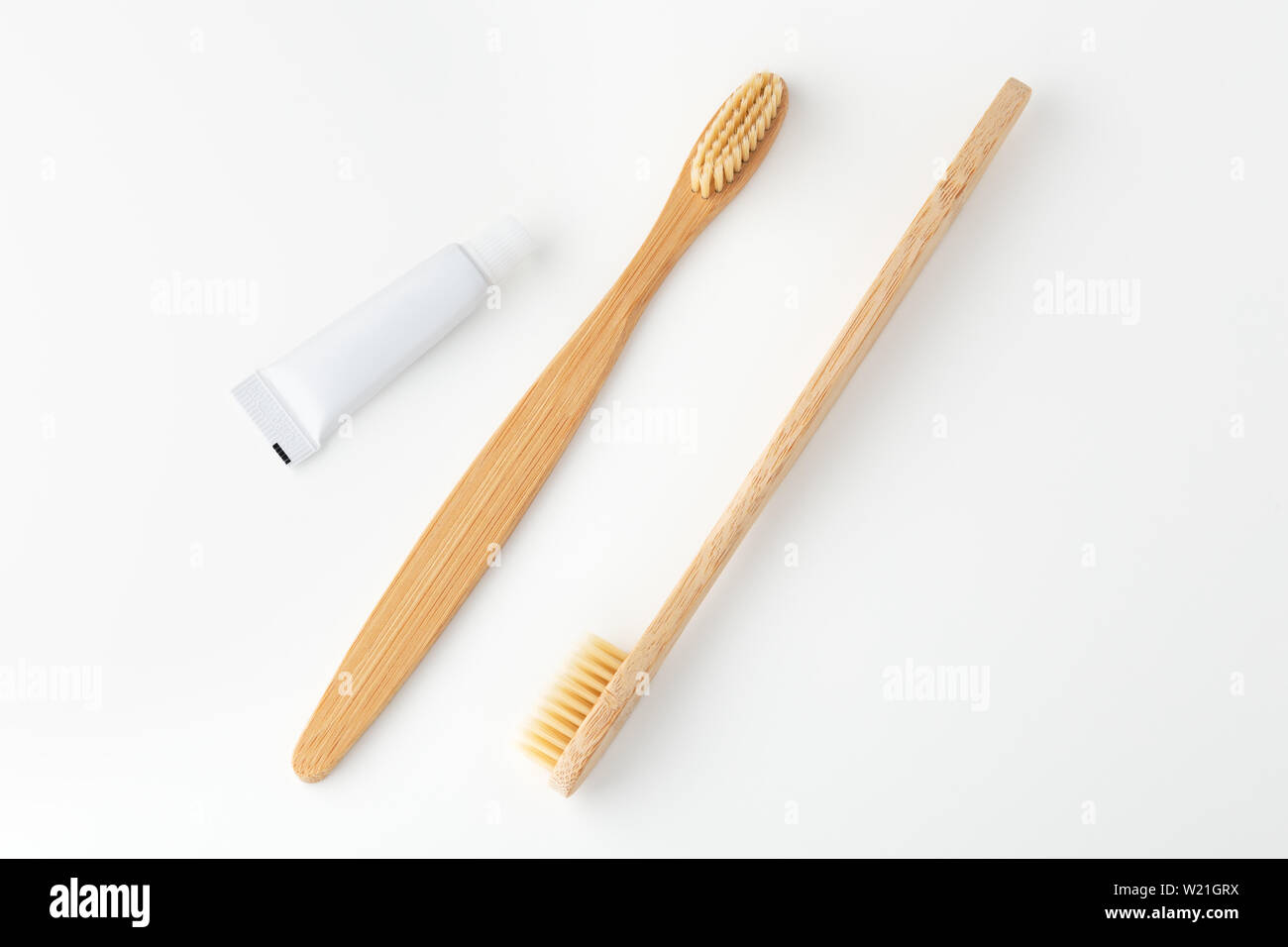 Bamboo toothbrushes and toothpaste, travel size, on white background ...