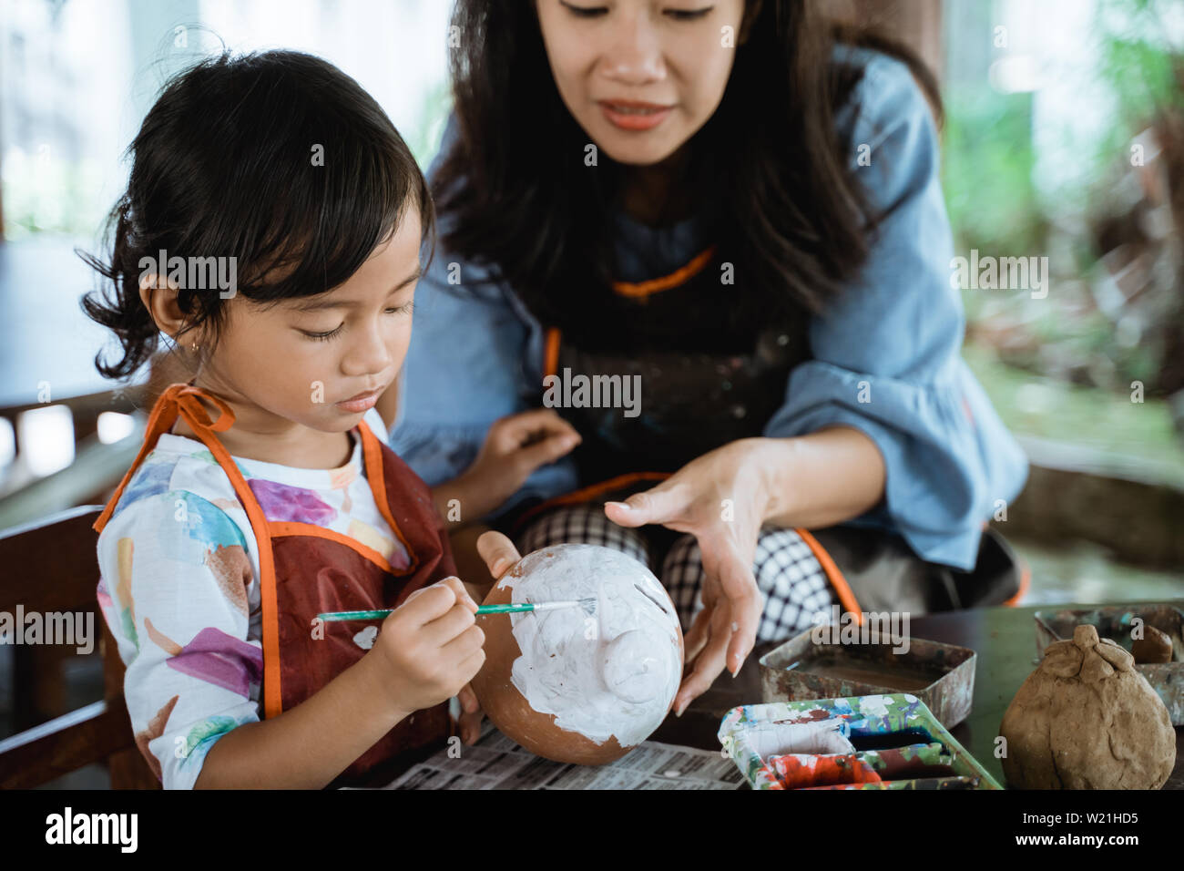 daughter learning about painting color with the guidance of his mother ...