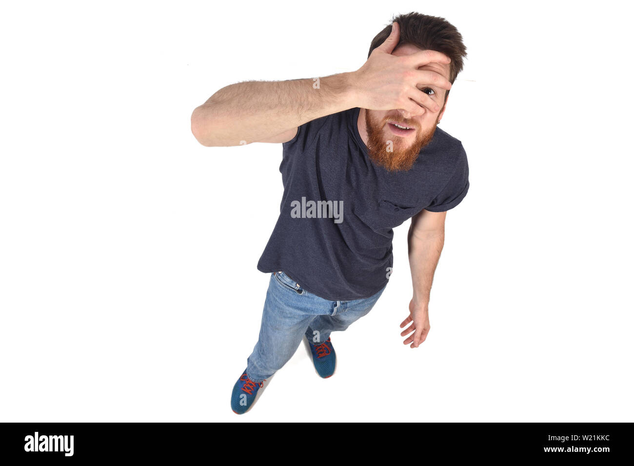 man peeking with hand on face on white background Stock Photo - Alamy