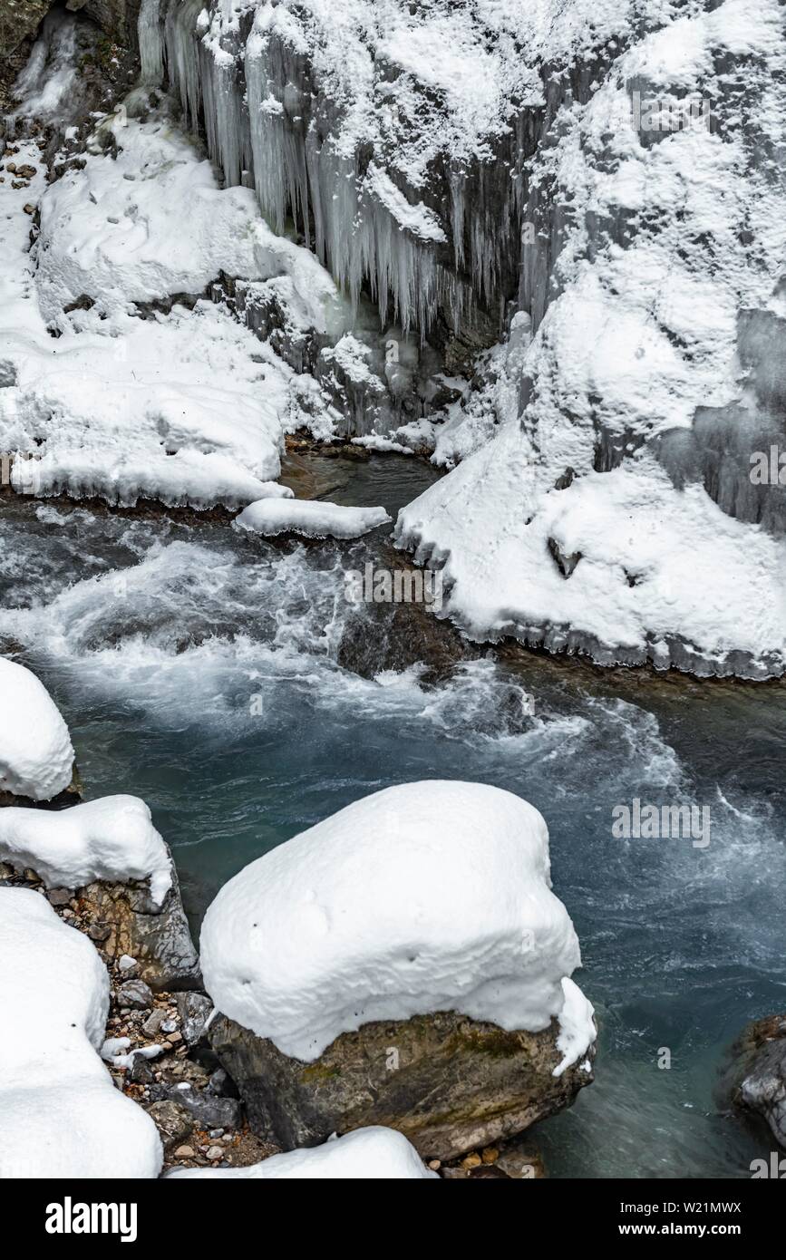 Wild river Partnach in the Partnachklamm with long icicles and snow in ...