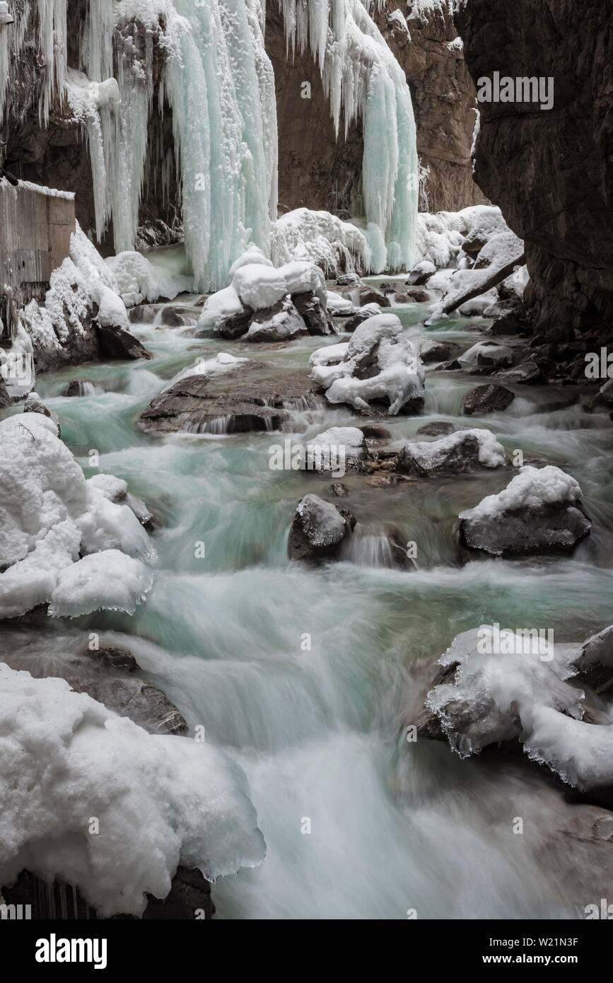 Wild river Partnach in the Partnachklamm with long icicles and snow in ...