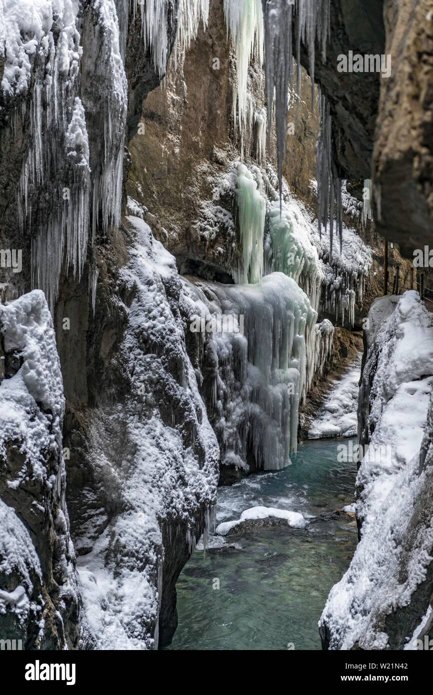 Wild river Partnach in the Partnachklamm with long icicles and snow in ...