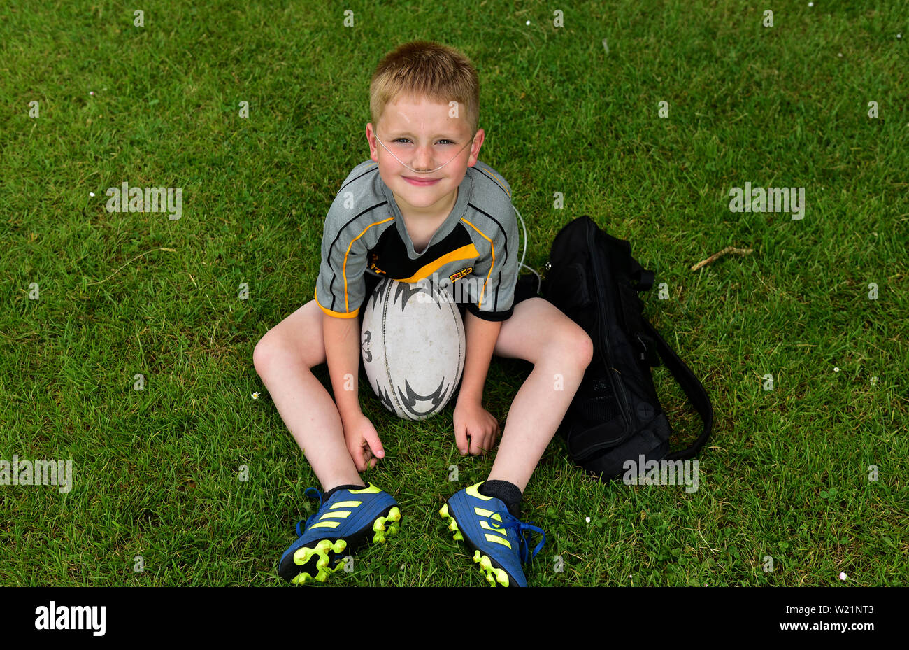 8-year-old Riley Davies playing rugby with an oxygen tank on his back ...